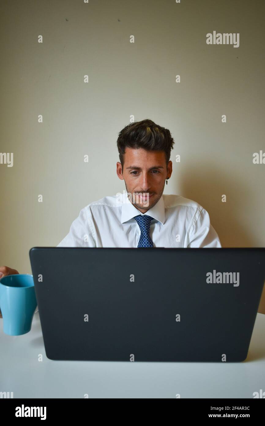 A vertical shot of a handsome Spanish man working in front of his ...
