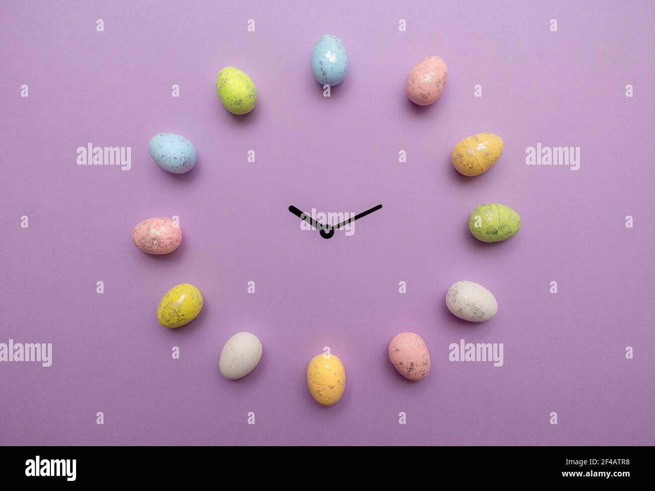 Colorful Easter eggs form a clock with clock hands in the middle on ...