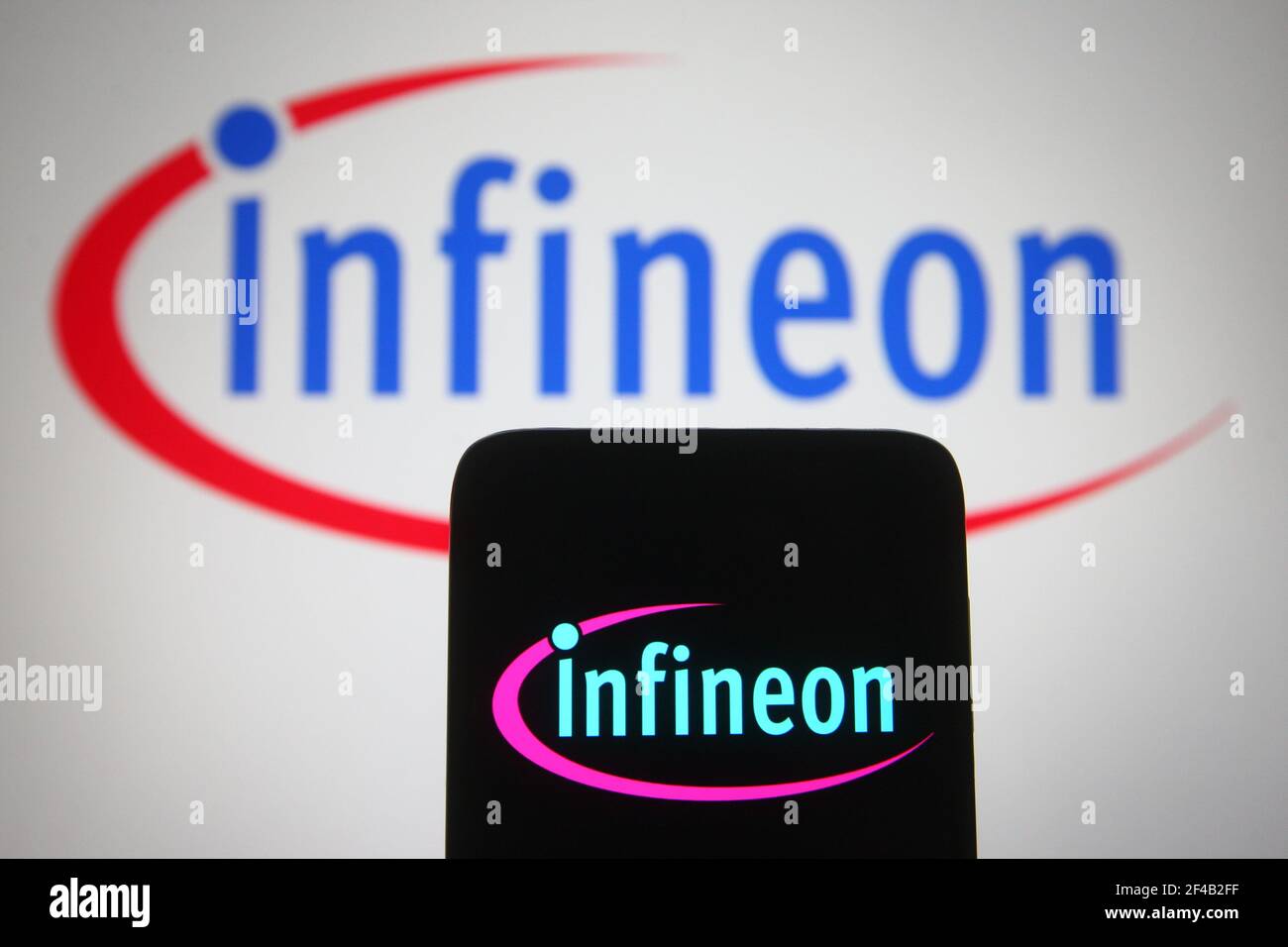 In this photo illustration, Infineon logo seen on a smartphone and a pc ...