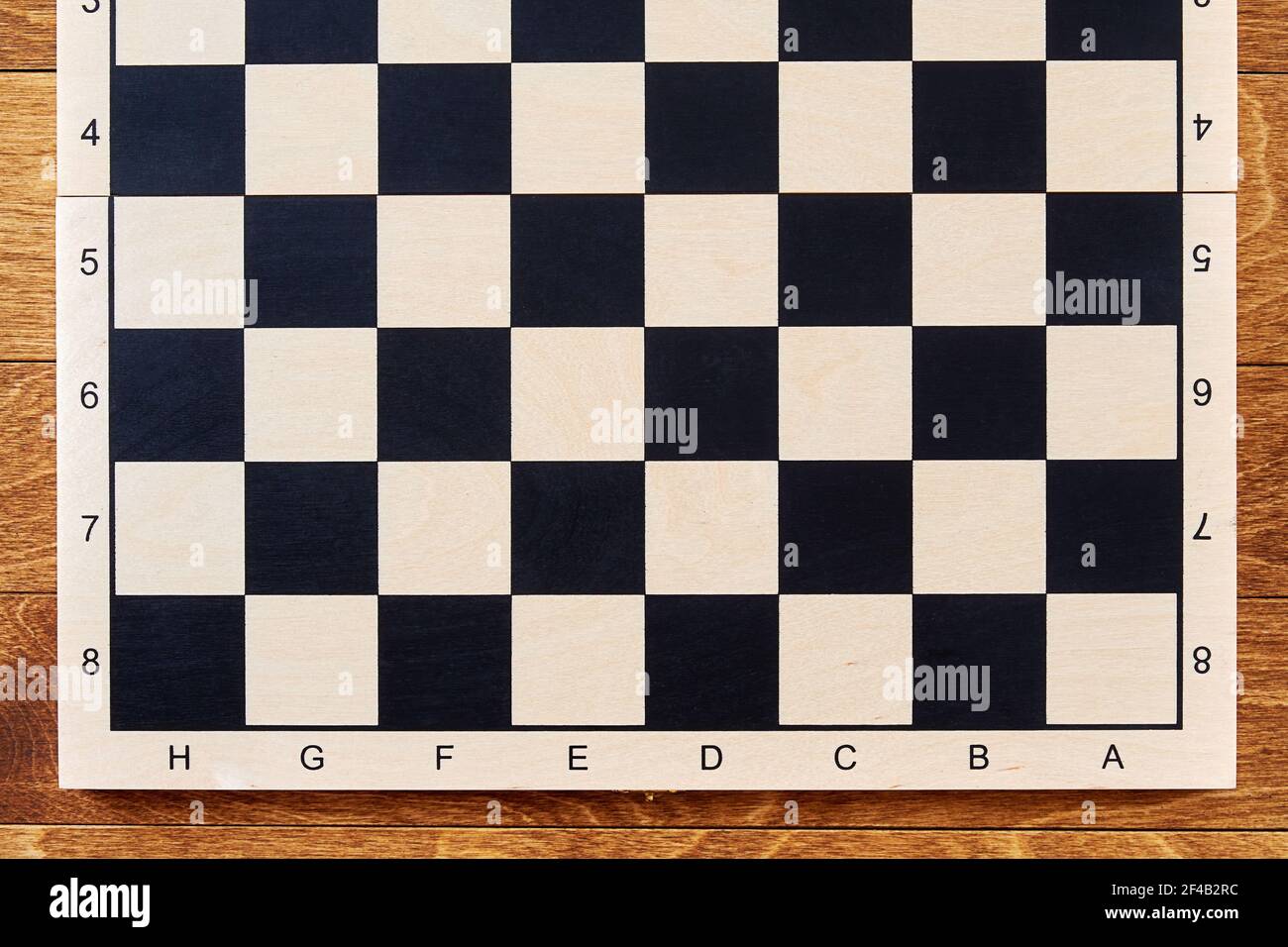 Classic empty half chessboard on the brown wooden table. Layout ...