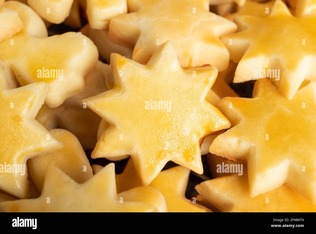 Pile of baked short bread sugar cookies in shape of stars. Traditional Swiss Christmas cookie ...