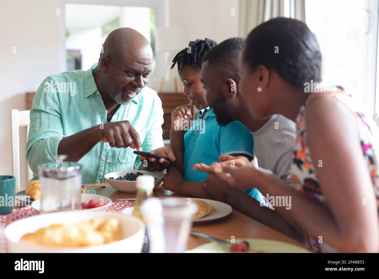 African american grandfather using smartphone with grandson and his ... African american grandfather using smartphone with grandson and his ...