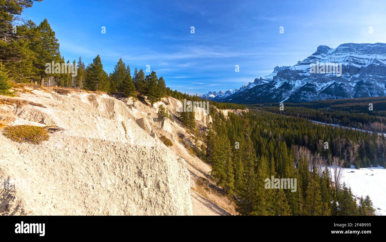 Eroded Sandstone Cliffs, Green Forest and Rundle Mountain Range Skyline ...