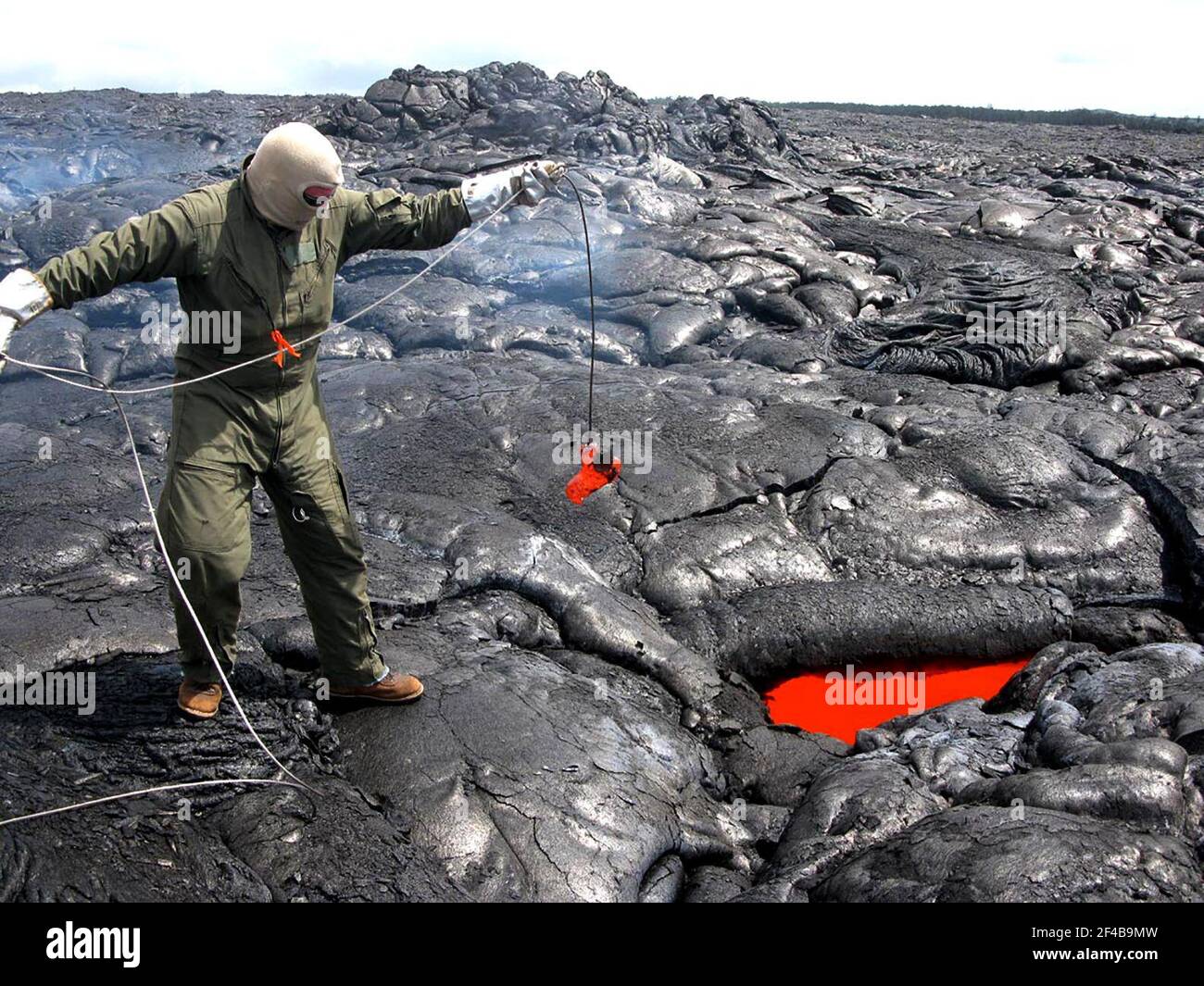 An HVO geologist samples lava from an active lava tube. These samples ...