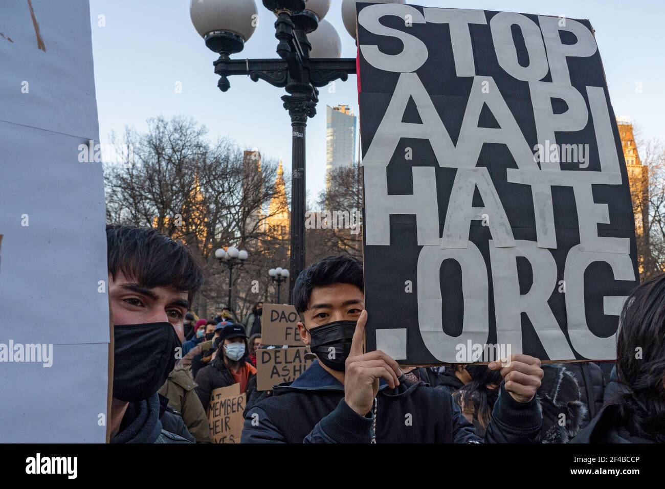 NEW YORK, NY - MARCH 19: A Protestor holds a sign that reads "stop aapi ...