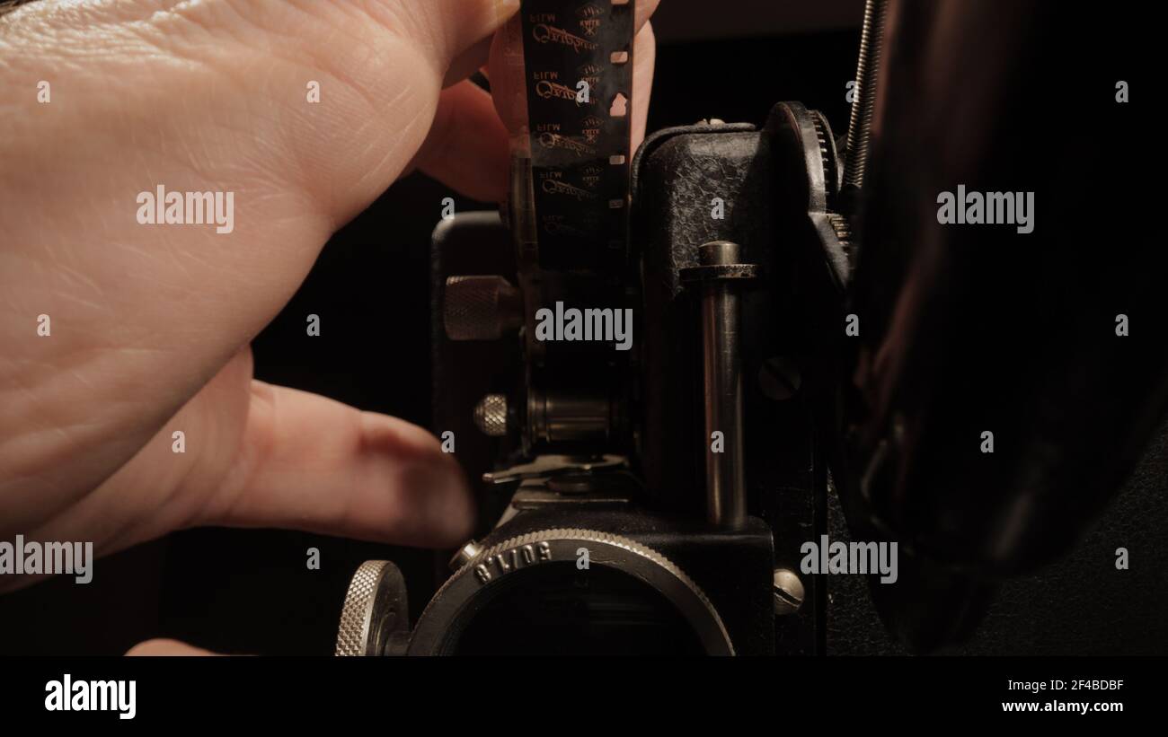 Inserting the film into an old film projector Stock Photo - Alamy