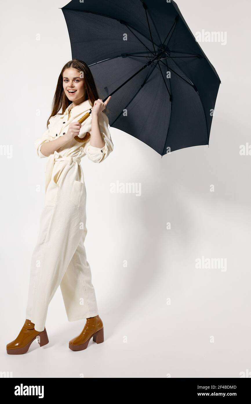 cheerful woman open umbrella over her head fashionable suit studio ...