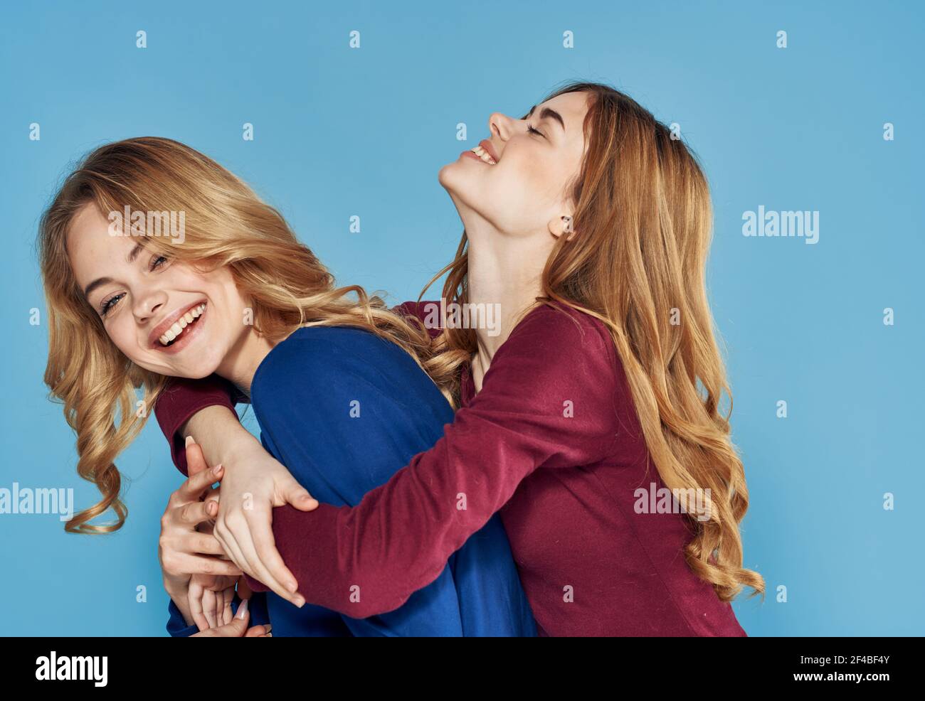 Elegant women in dresses hugs close-up lifestyle blue background Stock ...