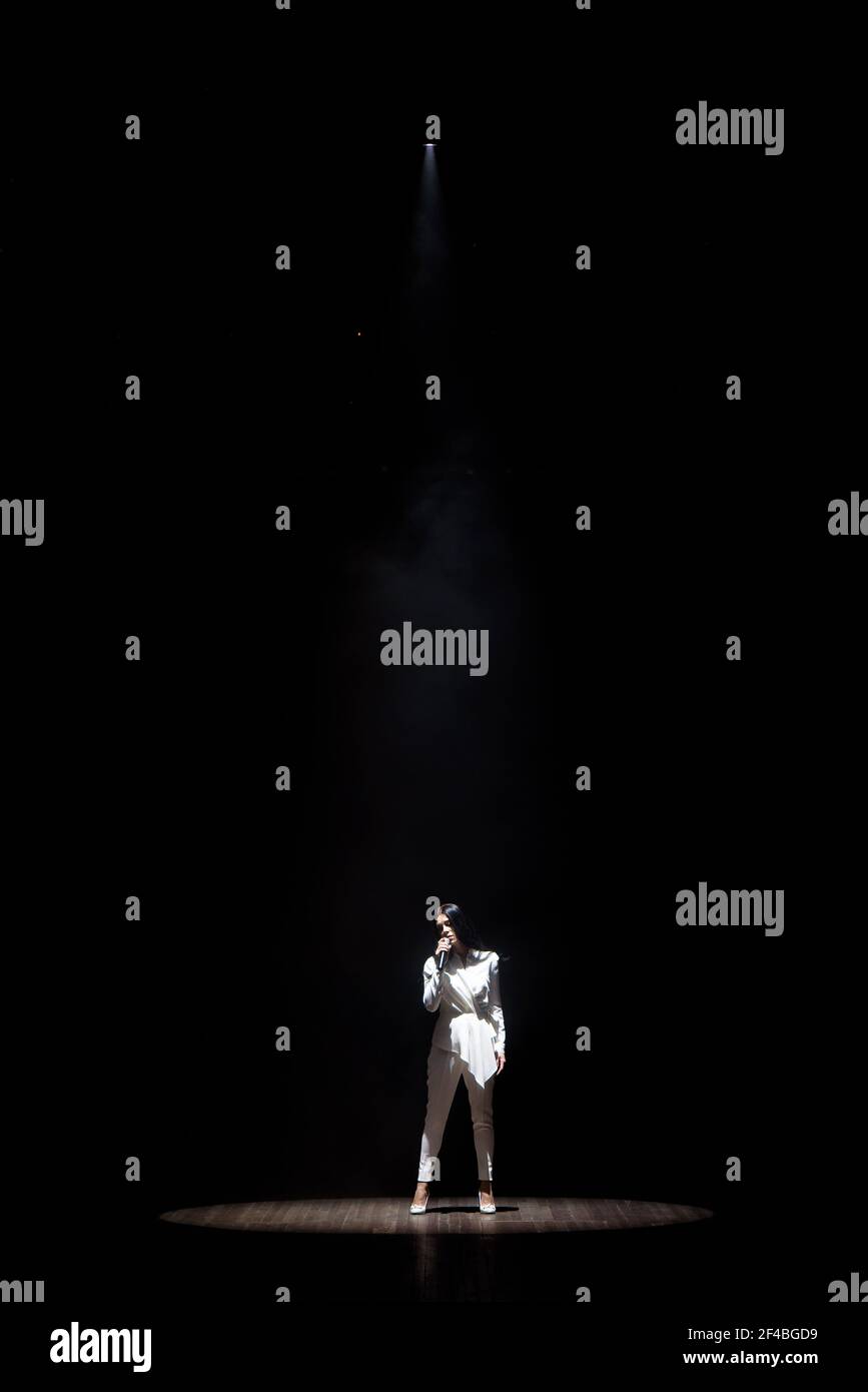 Artist performing live on scene in music hall Stock Photo - Alamy