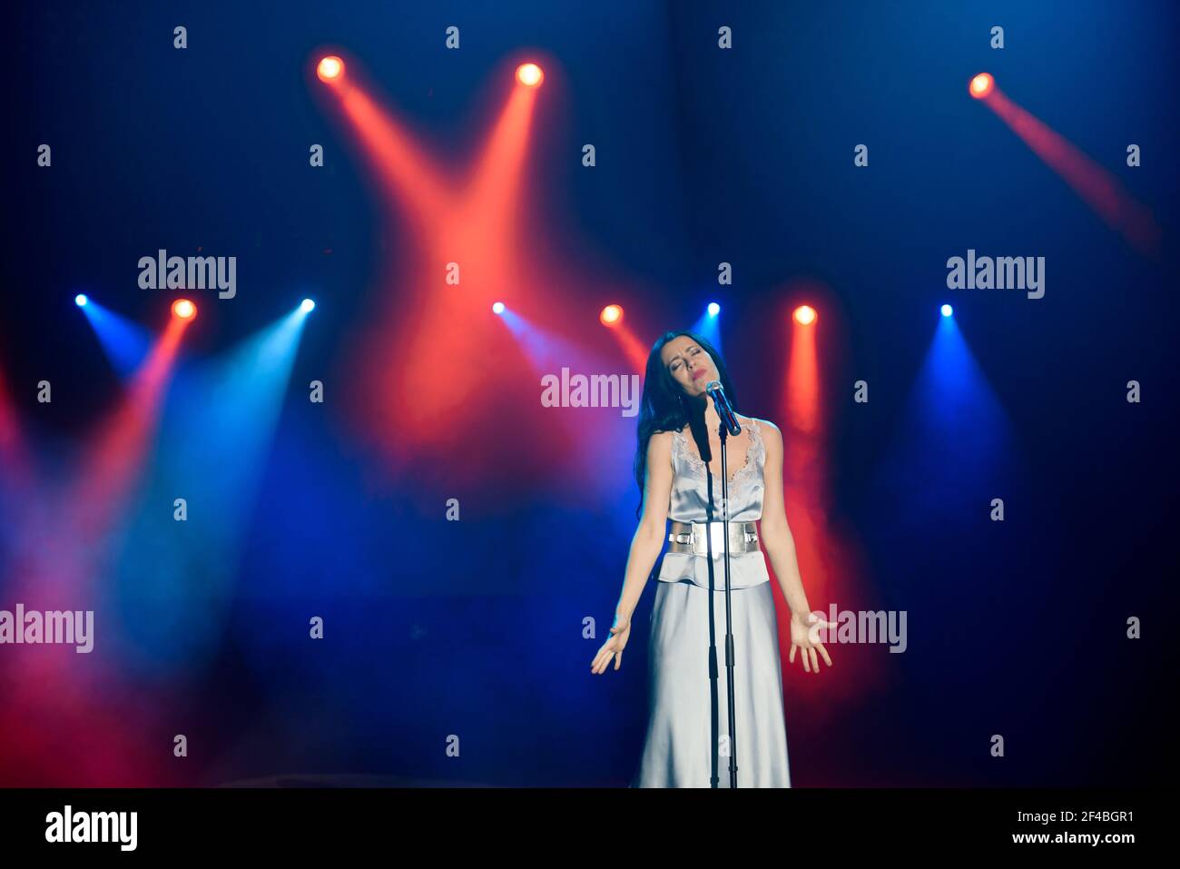 Singer with microphone on the colorful light stage background Stock ...
