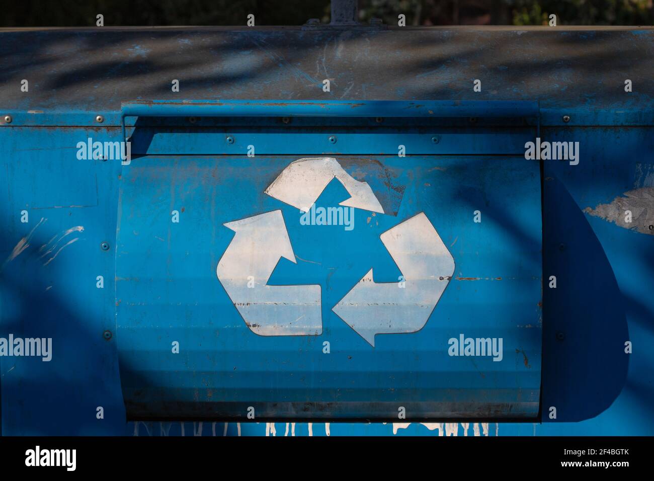 white recycling sign on the blue recycle bin. deformed recycling sign ...
