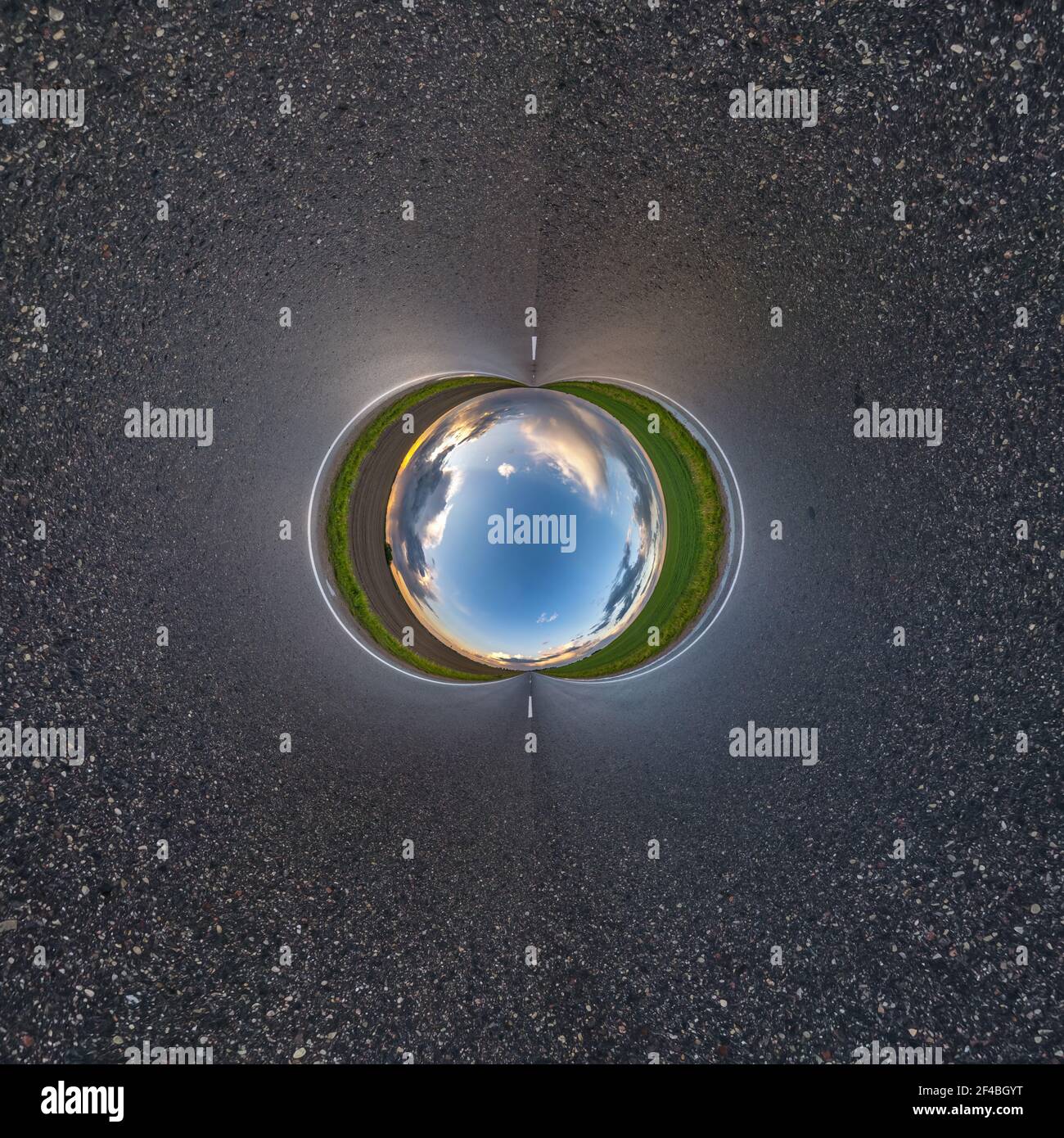 blue sky ball in middle of swirling asphalt road or field. Inversion of ...