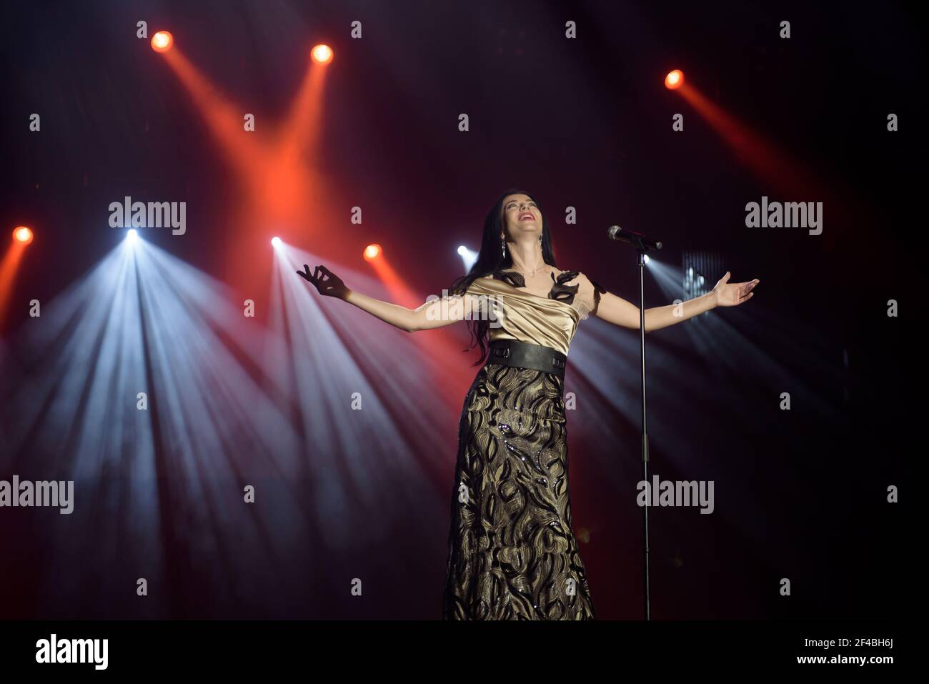 Singer in a dress on stage in the rays of bright light with smoke Stock ...