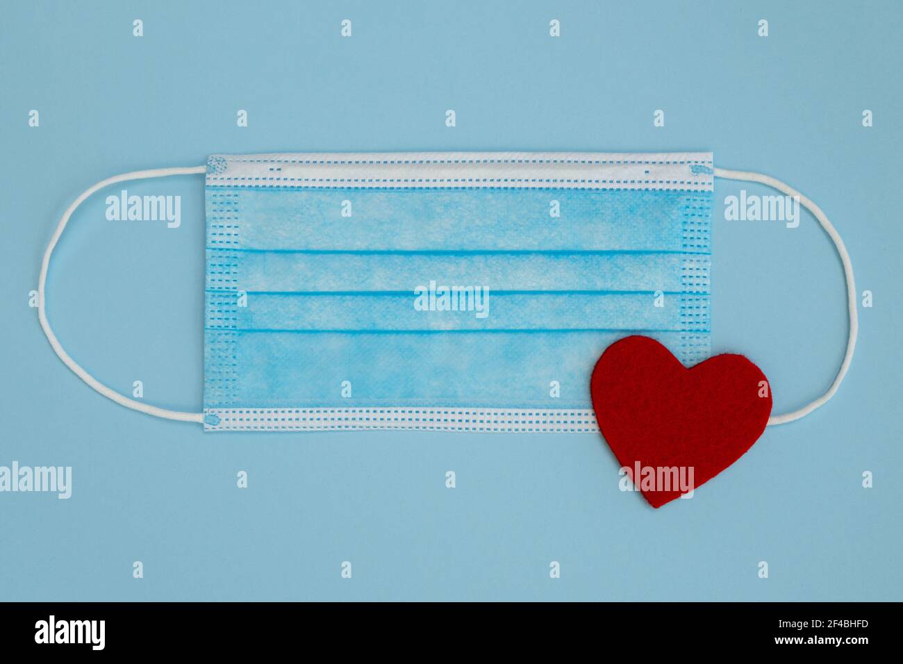 Medical mask on a blue background with red heart. Happy valentines day ...