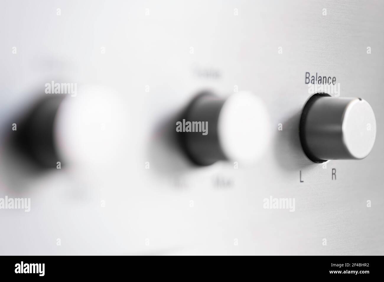 Rotary knobs on an amplifier with gray metal background. Focus on the ...