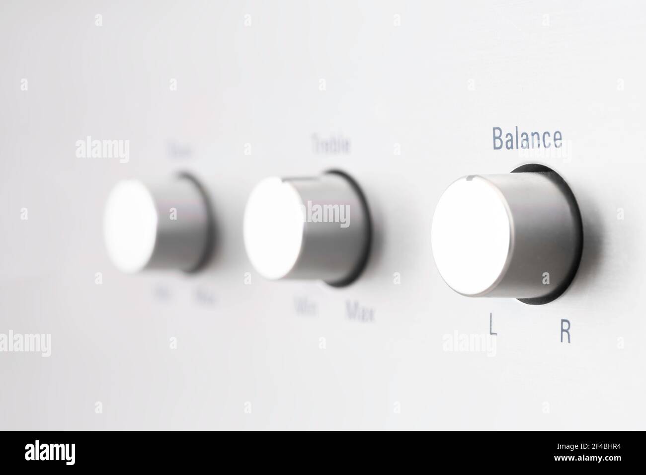 Rotary knobs on an amplifier with gray metal background. Focus on the ...