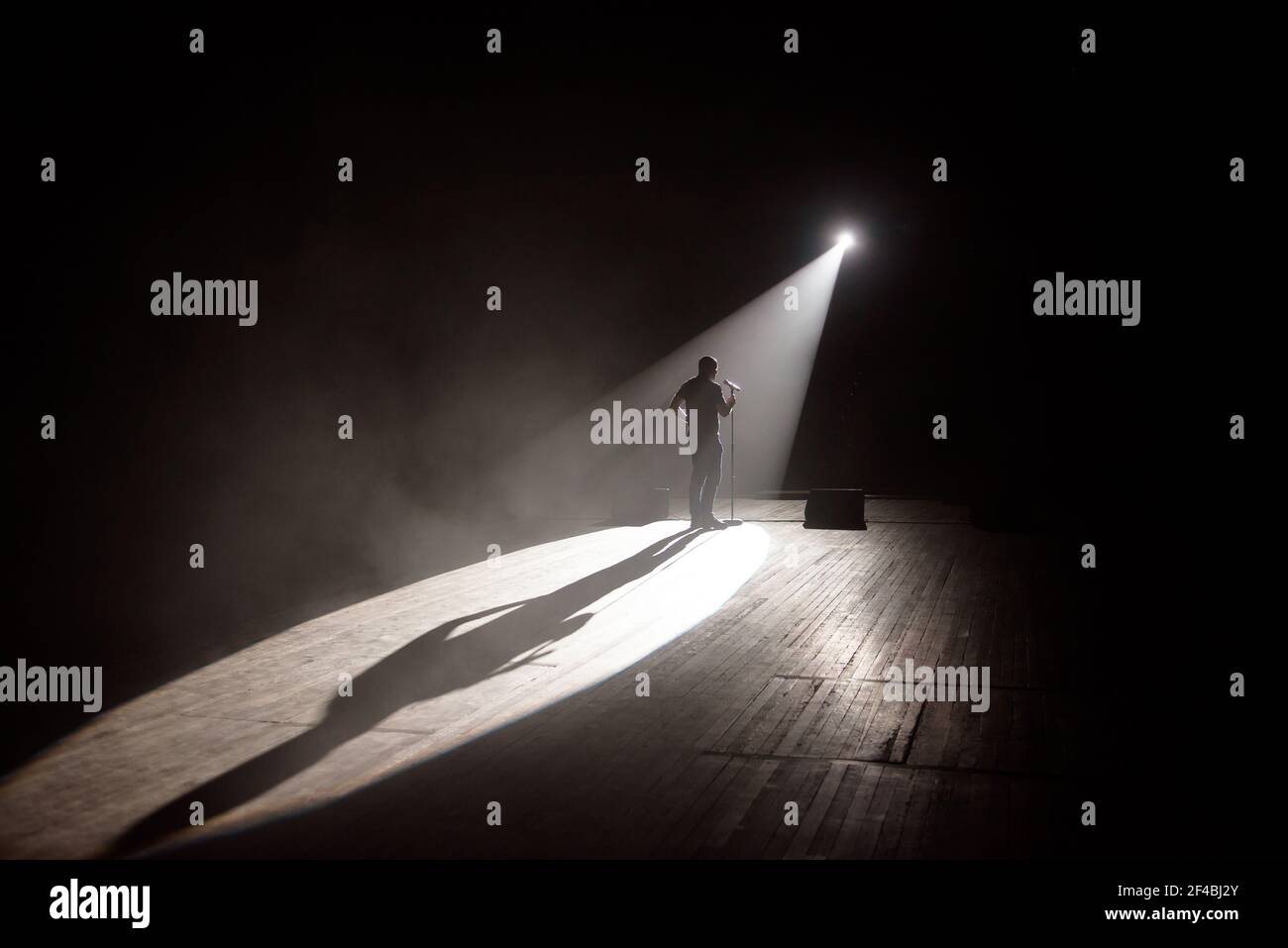 Stand up comedian on stage in the beam of light Stock Photo - Alamy