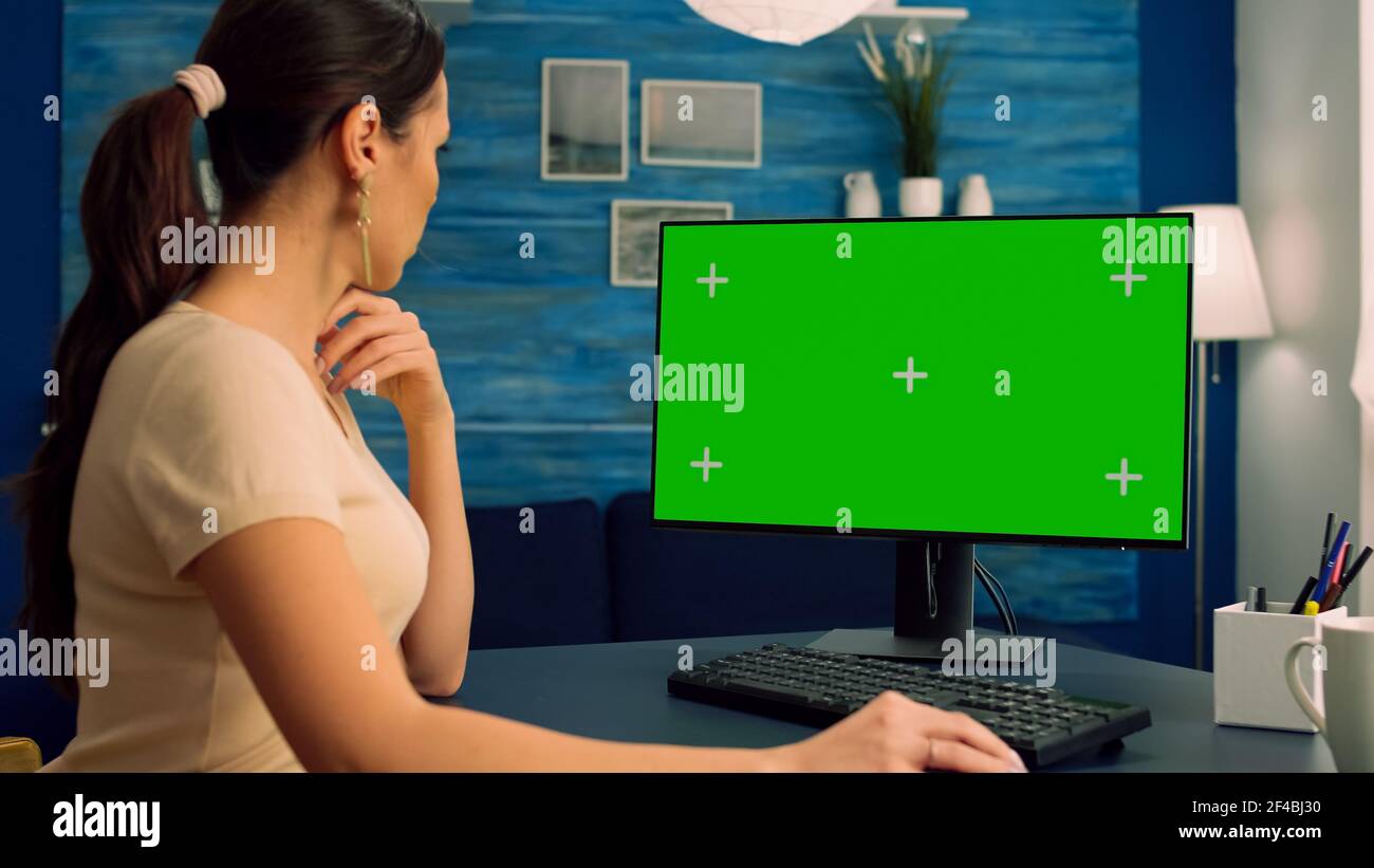 Caucasian female searching on computer with mock up green screen chroma ...