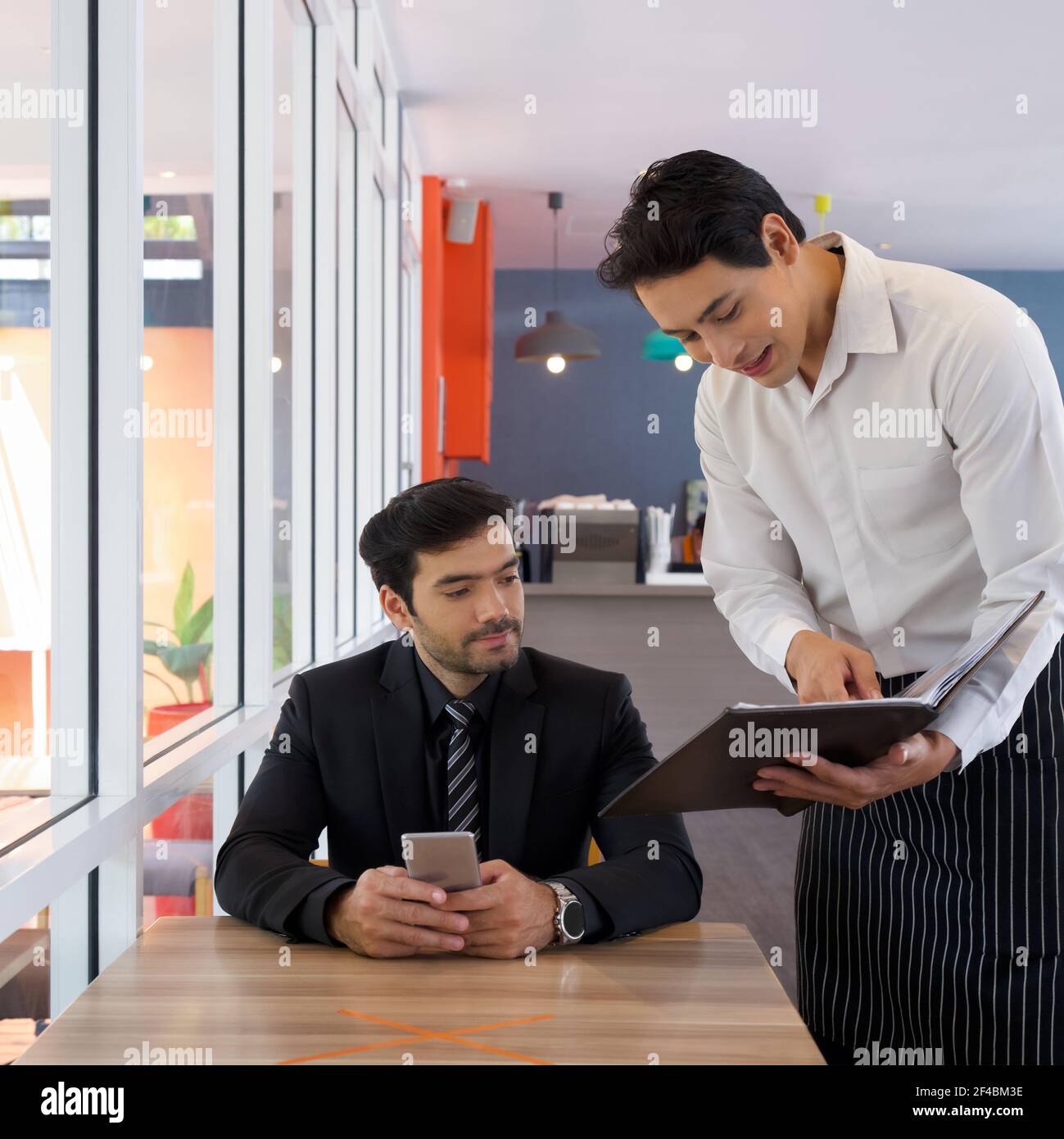 Restaurant staff pointing menu hi-res stock photography and images - Alamy