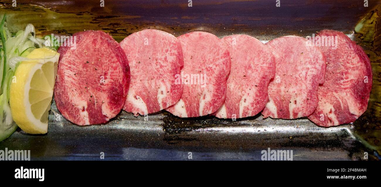 Atsui Tan, Ox tongue sliced served on a black tray with Japanese ...