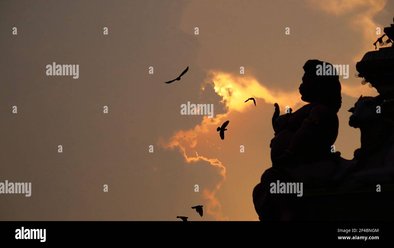 Hindu Statues In Silhouette At Sunset : Religious statues at Batu Caves ...