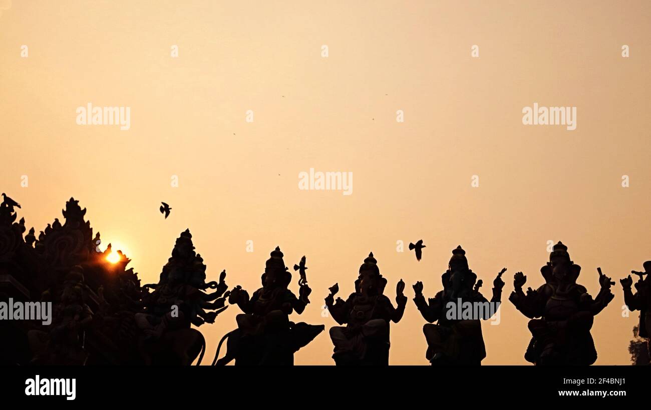 Hindu Statues In Silhouette At Sunset : Religious statues at Batu Caves ...