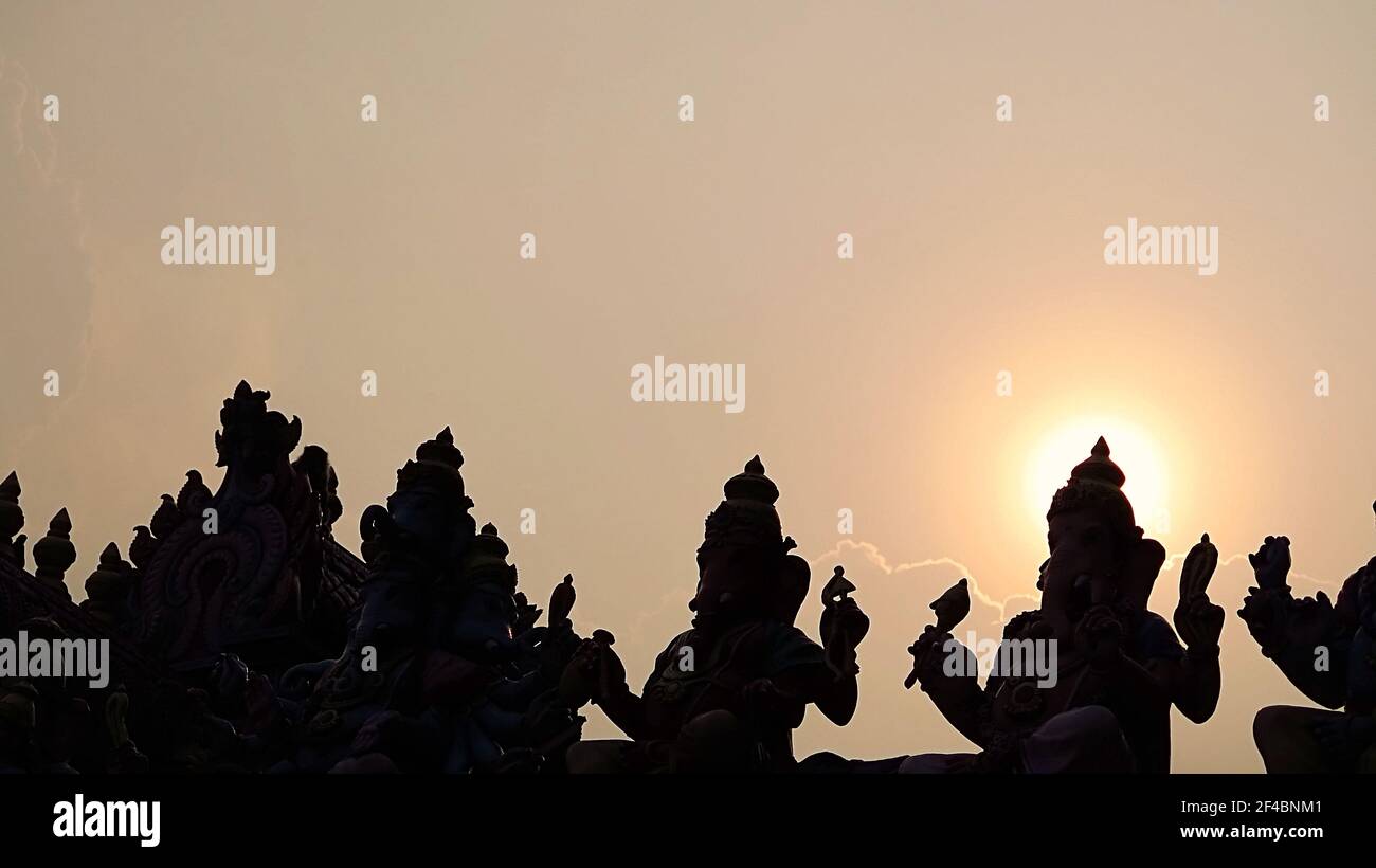 Hindu Statues In Silhouette At Sunset : Religious statues at Batu Caves ...