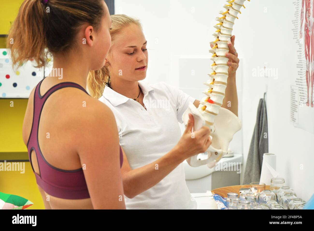 Young woman patient at physiotherapy consultation, therapist explaining ...