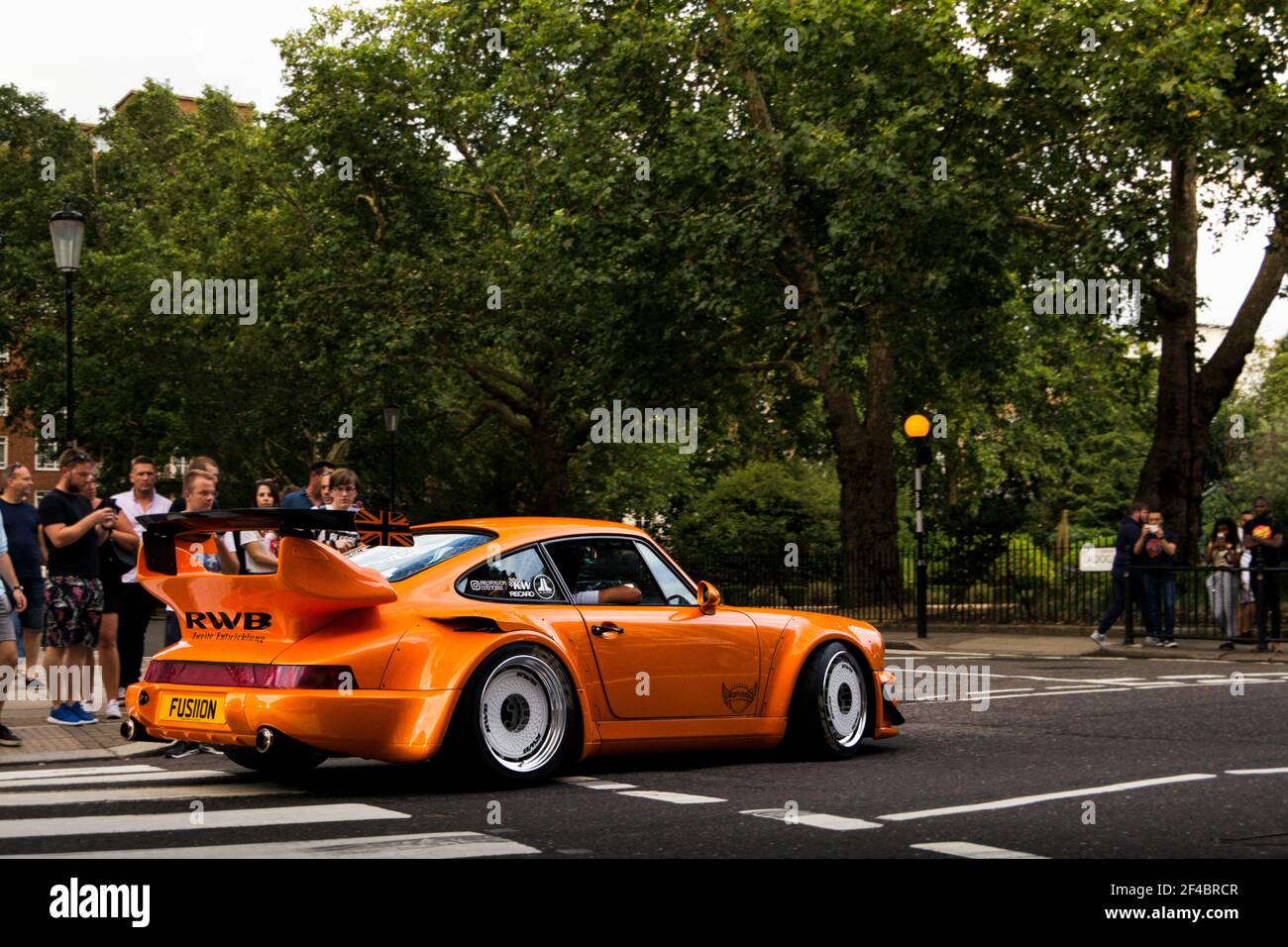 Orange Porsche 911 RWB modified classic supercar driven on a street in ...