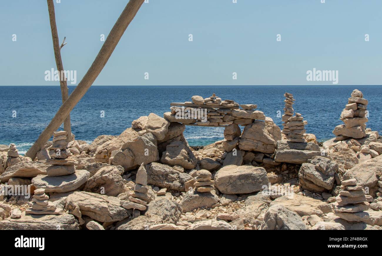 Sea pebbles sculptures against blue sea and clear sky. Pebbles ...