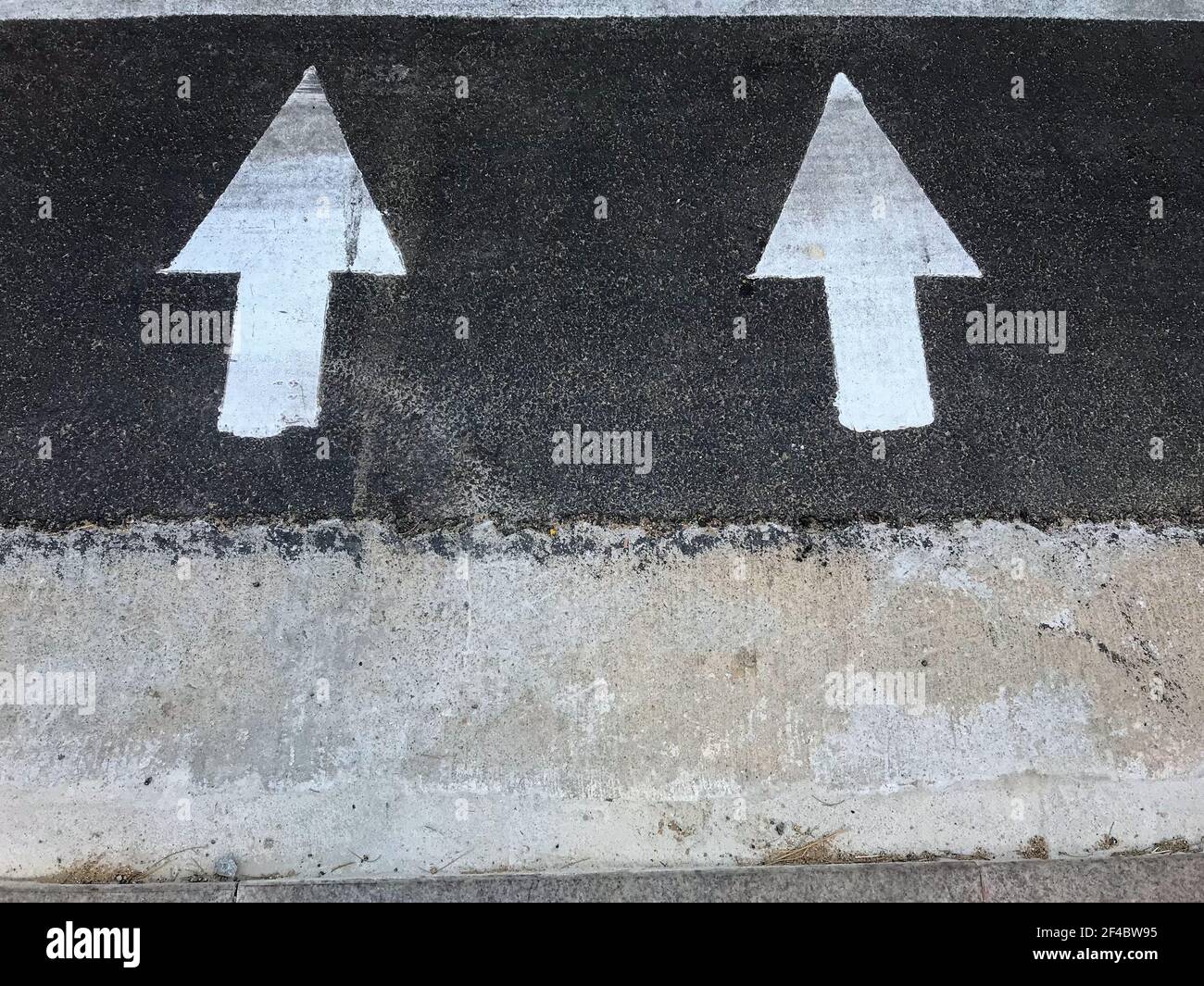 Tow white arrows on a street pointing in the same direction Stock Photo ...