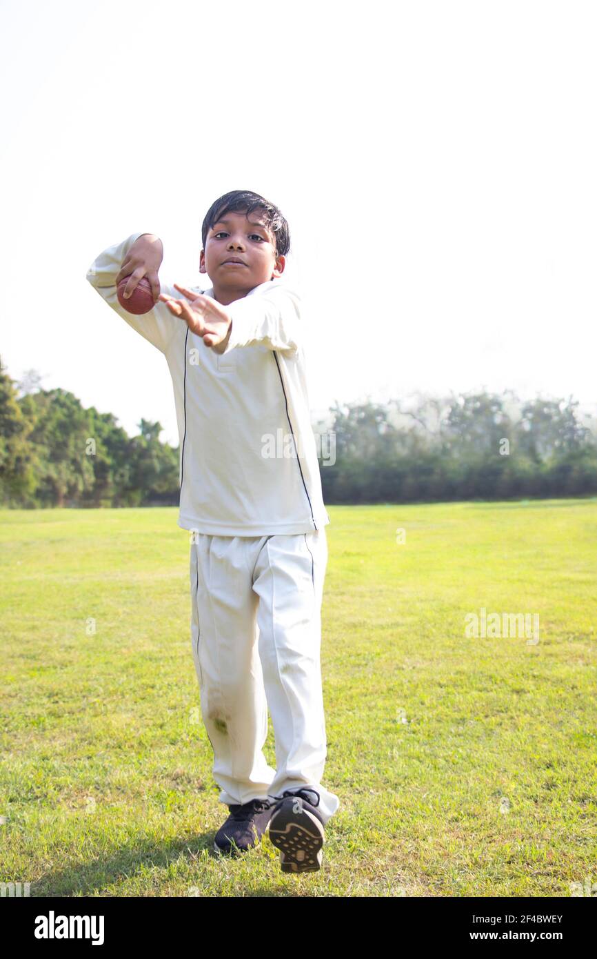 Young boy bowling leg spin in a cricket Stock Photo - Alamy