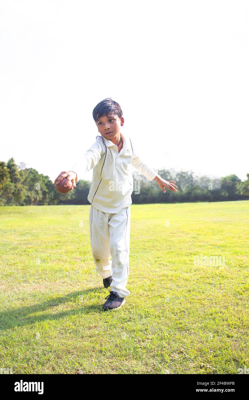 Young boy bowling leg spin in a cricket Stock Photo - Alamy