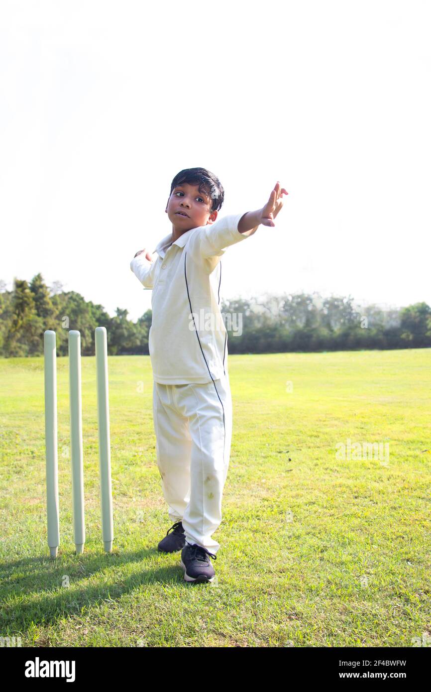 Young boy bowling leg spin in a cricket Stock Photo - Alamy