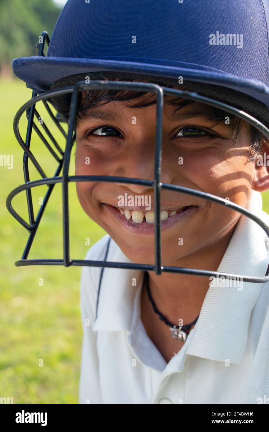 Portrait of boy wearing cricket helmet and smiling Stock Photo - Alamy