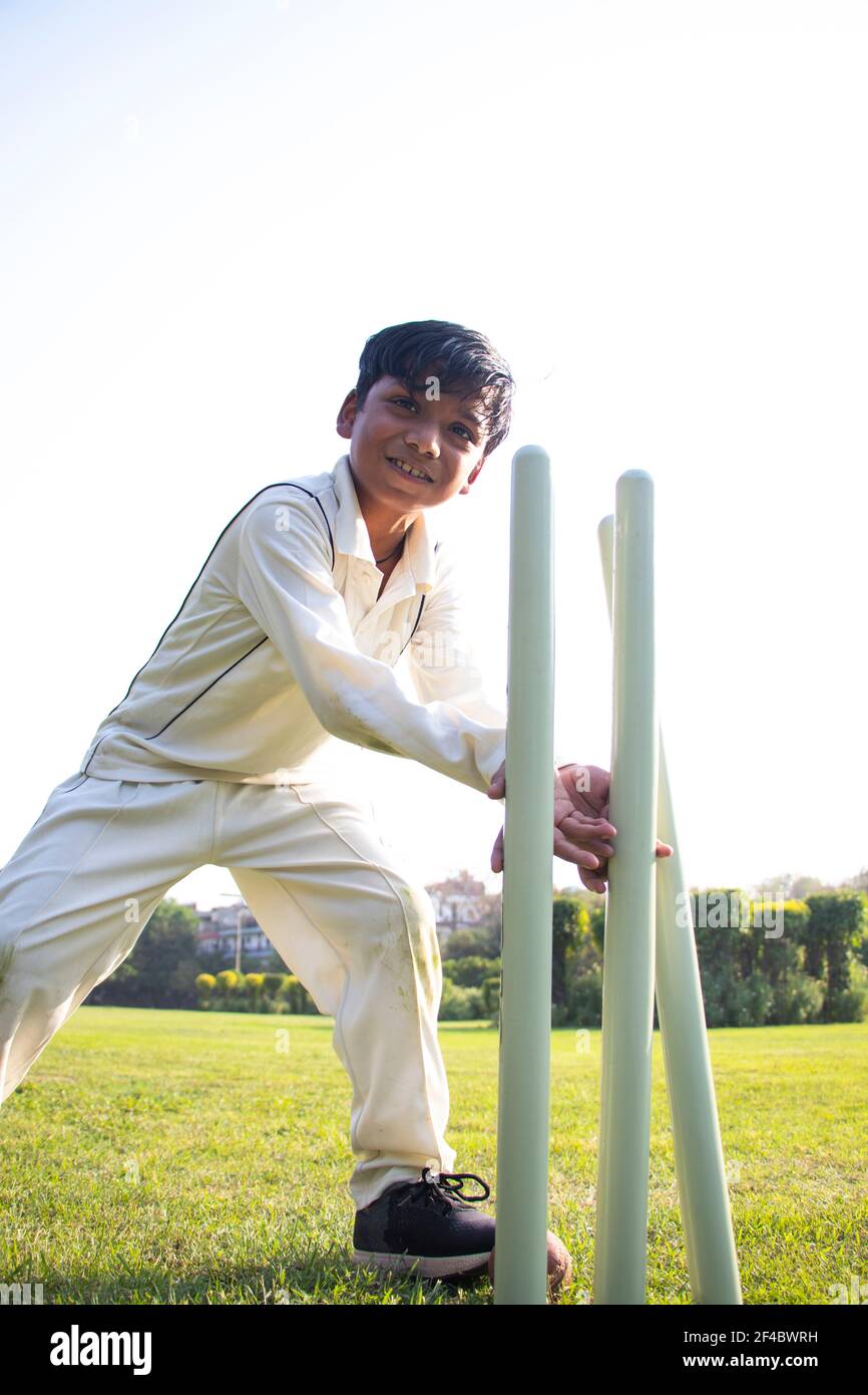 a boy fielding on the grounds during cricket game Stock Photo - Alamy