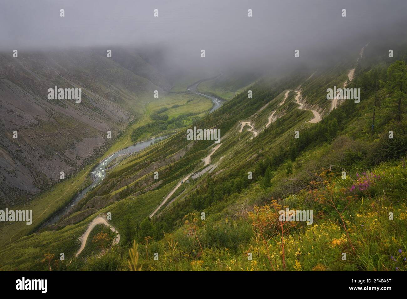 Scenic top view on steep mountain slope with winding dirt rocky road ...