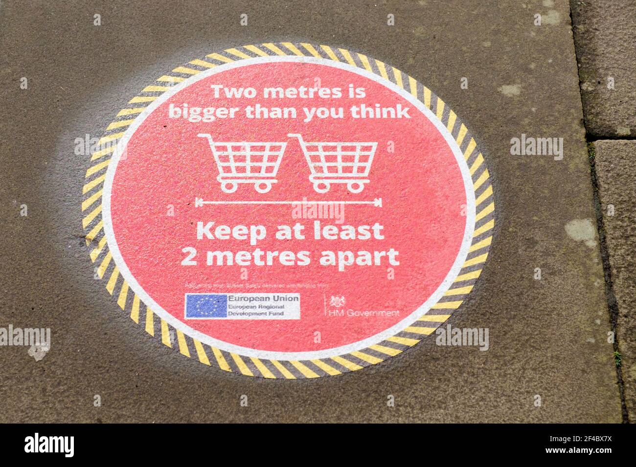 a 2 metre distance pavement sign in Bristol City Center. Social ...