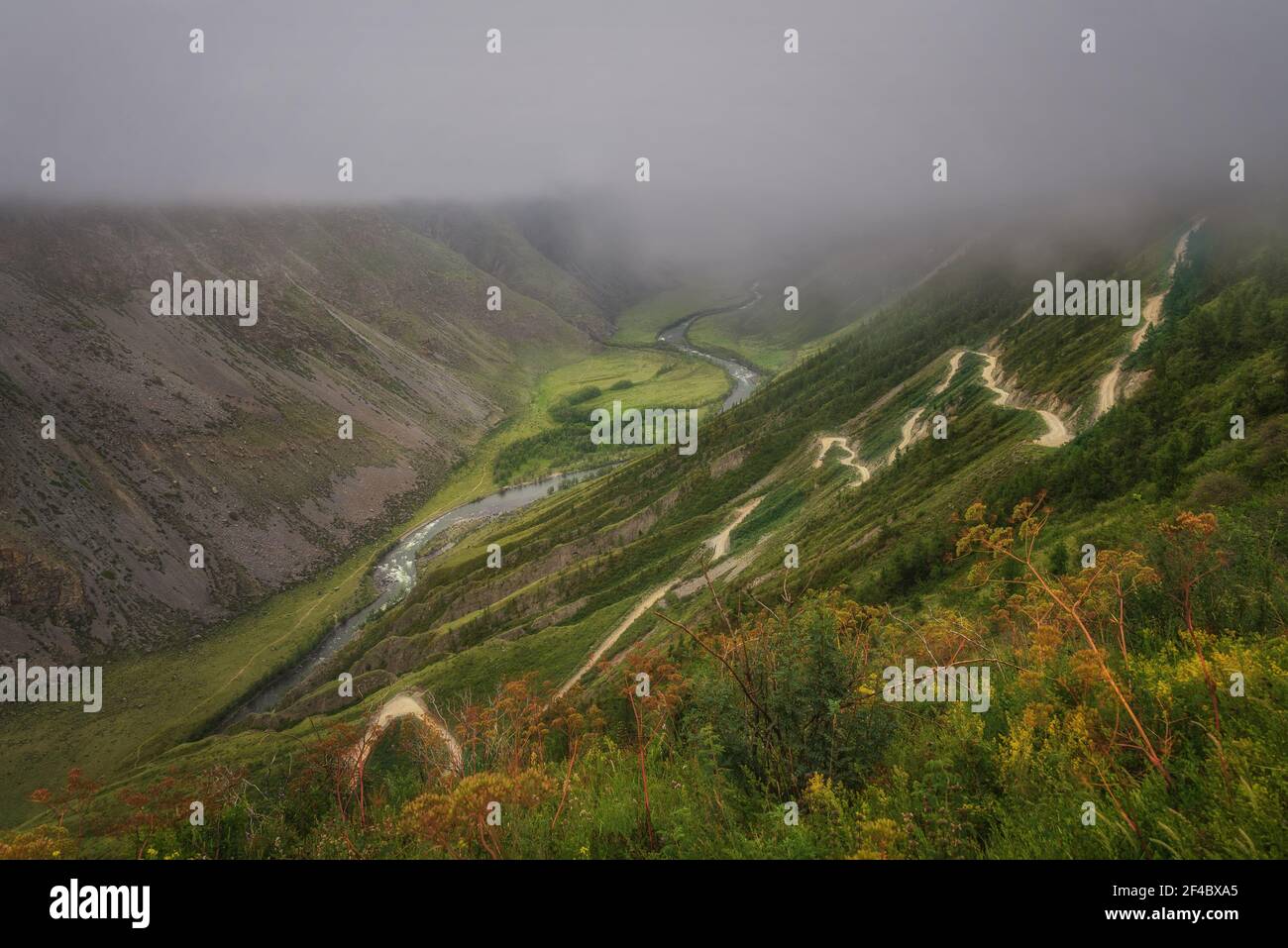 Scenic top view on steep mountain slope with winding dirt rocky road ...