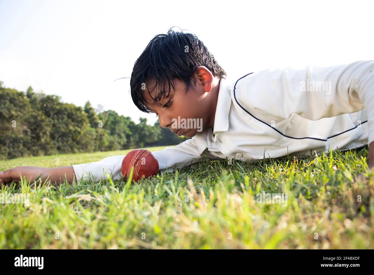 a boy fielding on the grounds during cricket game Stock Photo - Alamy
