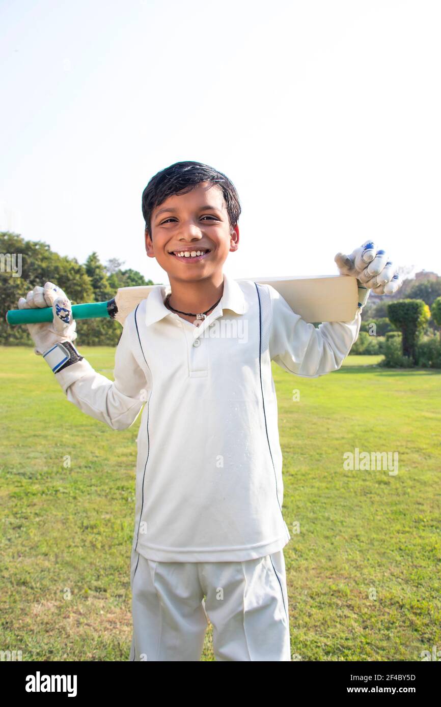 Boy in cricket uniform holding a cricket bat Stock Photo - Alamy