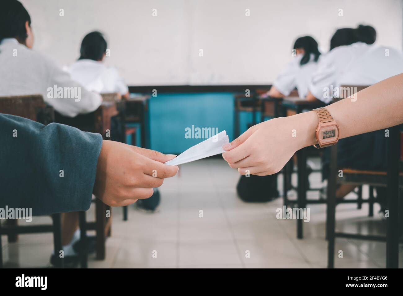 Students passing notes to each other secretly during class Stock Photo ...
