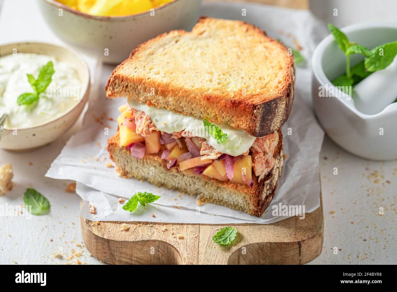 Homemade sandwich with chicken, fruits, onion and herbs. Exotic lunch ...