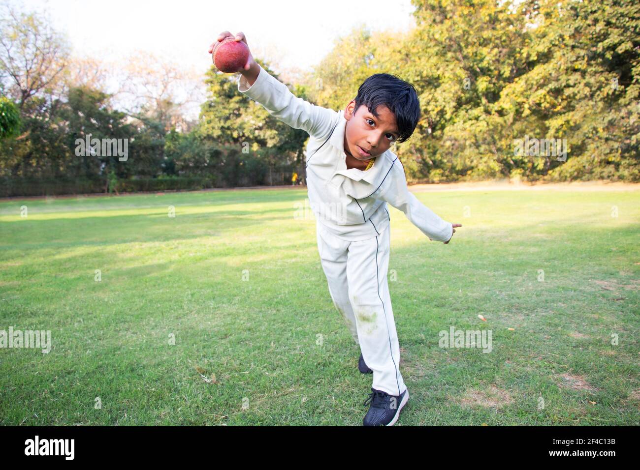 Young boy bowling leg spin in a cricket Stock Photo - Alamy