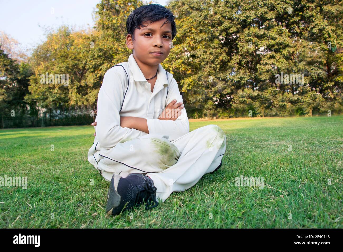 a boy sitting on the ground during a cricket Stock Photo - Alamy