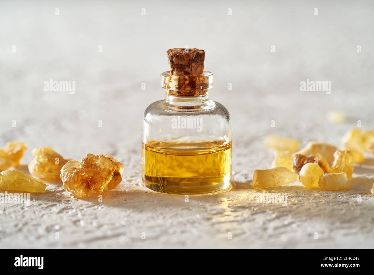 A bottle of essential oil with frankincense resin on white background ...