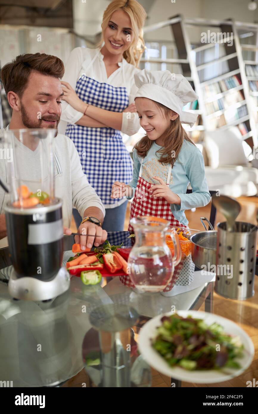 Joyful caucasian parents cooking with daughter at home Stock Photo - Alamy