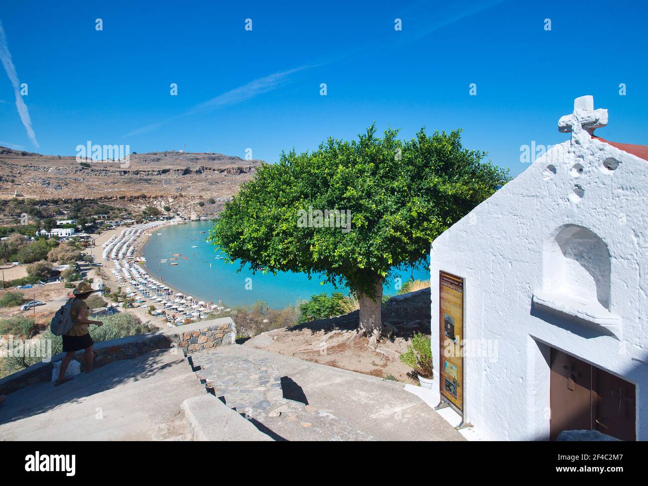 Greek orthodox church on the hillside with Lindos Beach, Rhodes ...