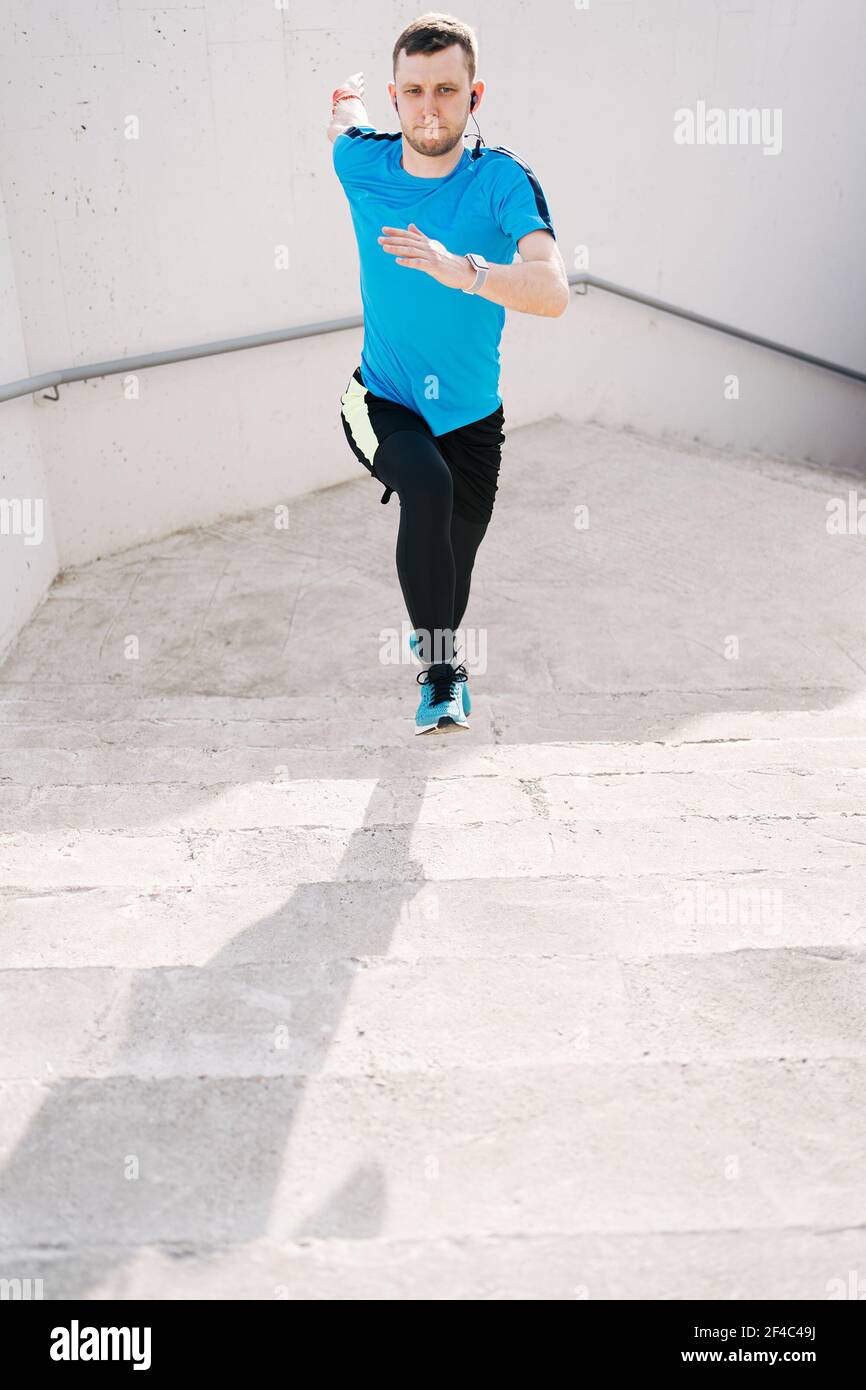 Young man running upstairs on city stairs. Fitness, sport, people ...