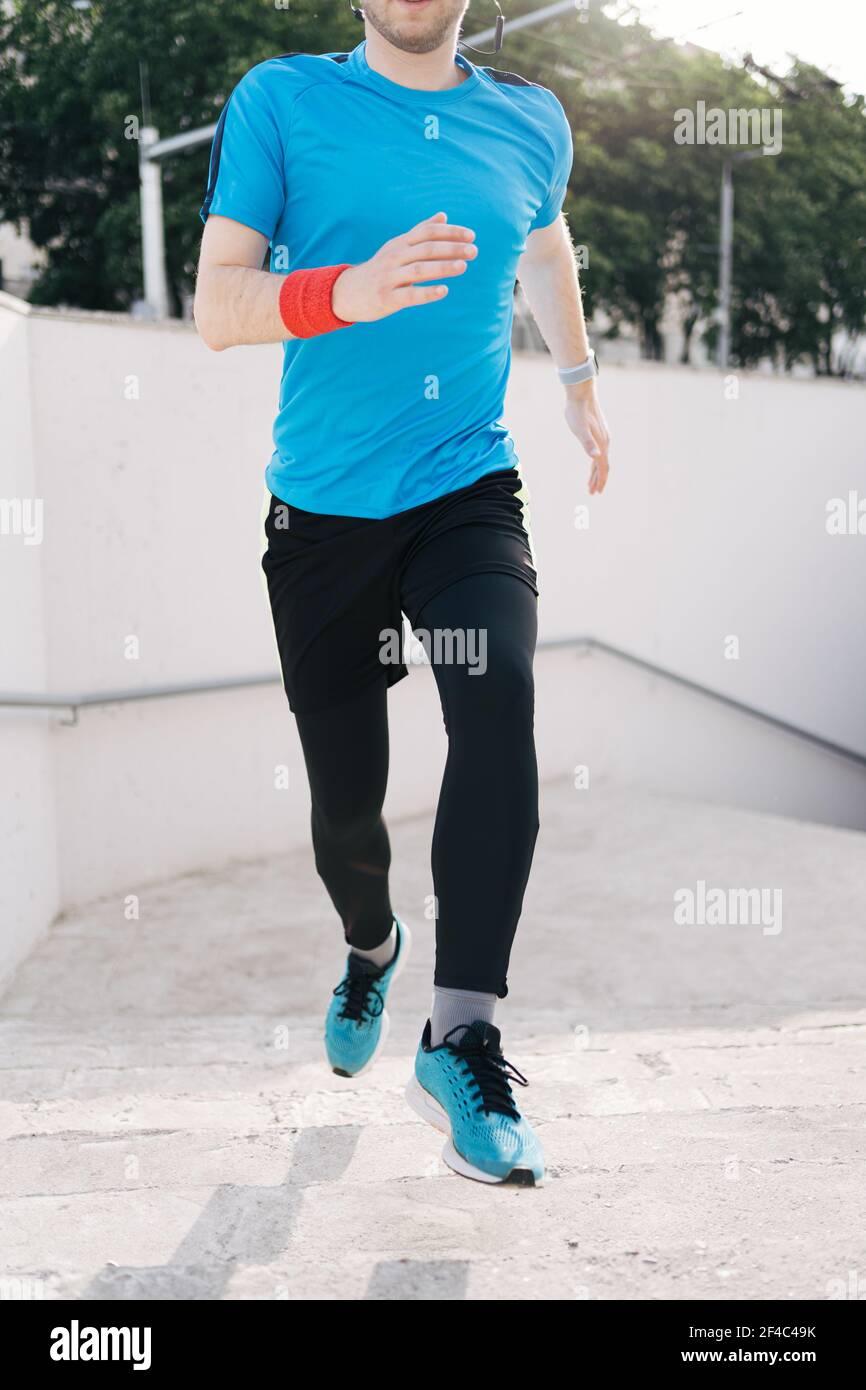 Young man running upstairs on city stairs. Fitness, sport, people ...